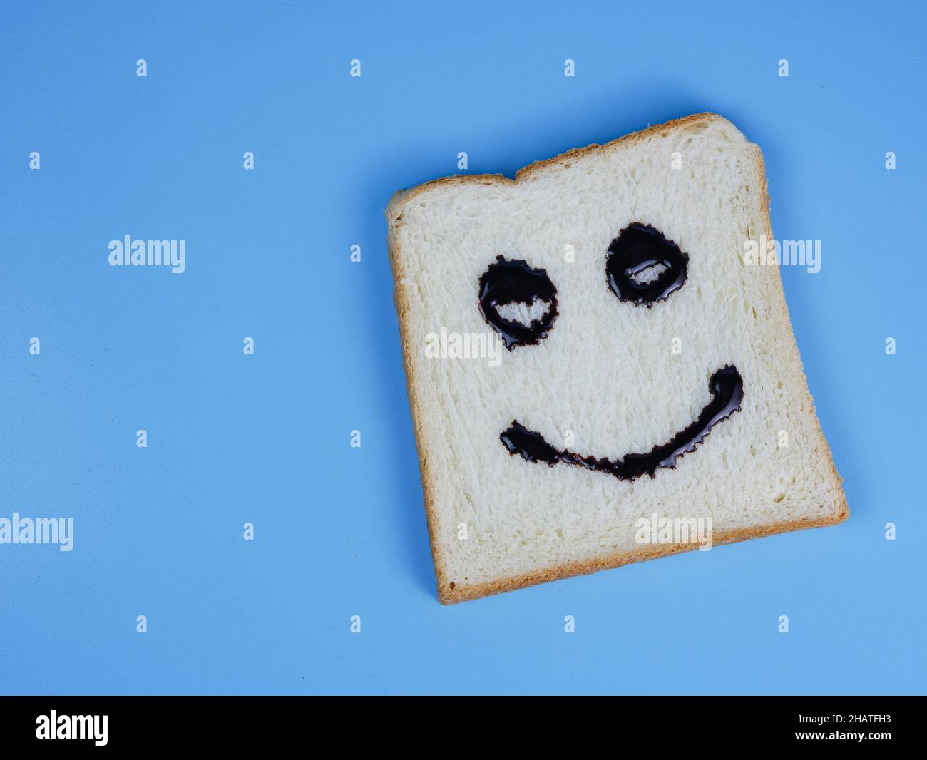white bread with smiley emoticon on blue pastel background Stock Photo ...