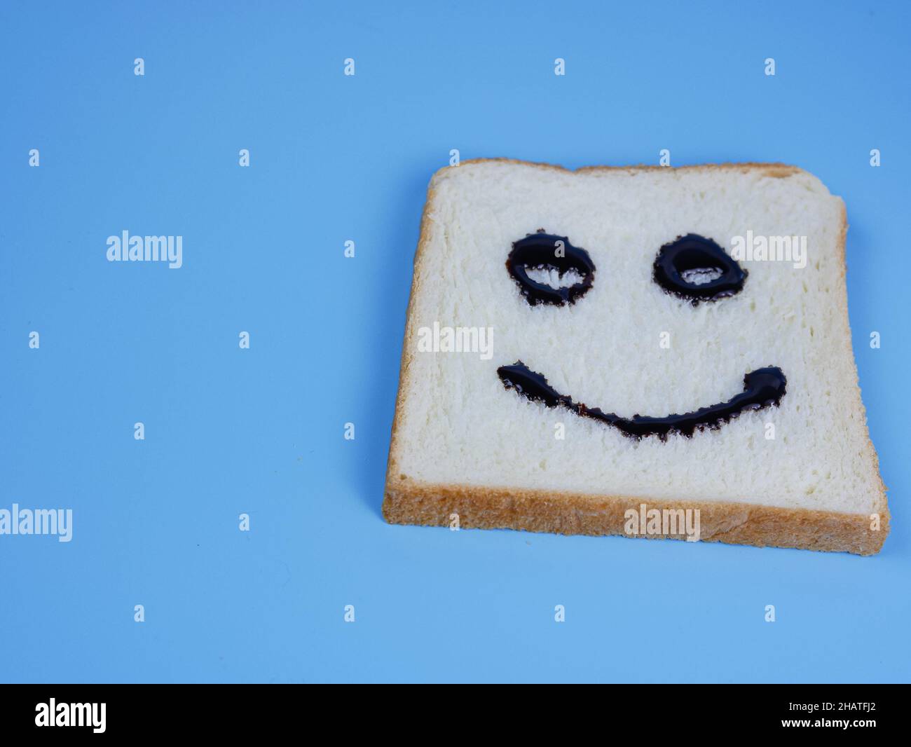 white bread with smiley emoticon on blue pastel background Stock Photo ...