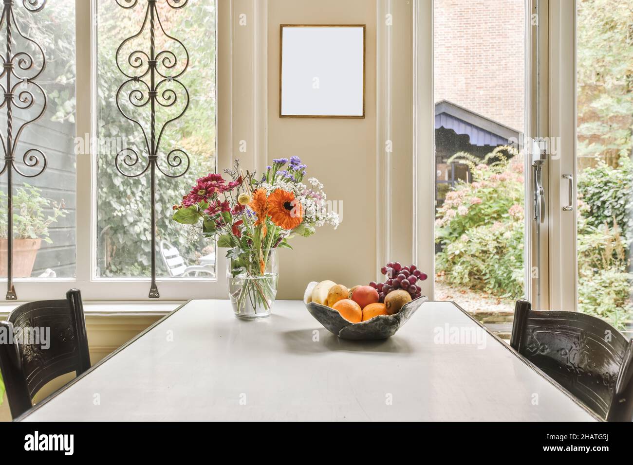 Dining table with beautiful flowers in a vase and fruits and a window ...