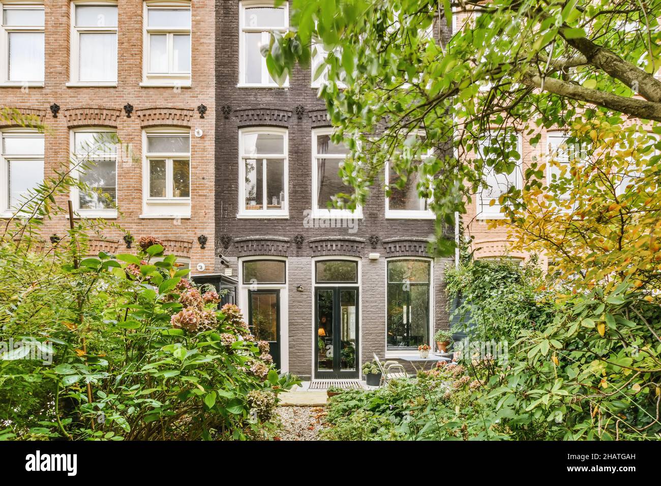 View of a brick building with lots of greenery Stock Photo - Alamy