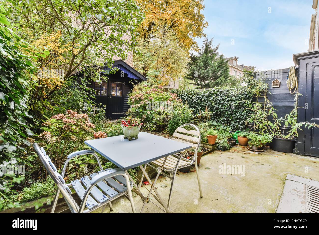 Fabulous courtyard with lots of greenery and a table with a chair and a ...