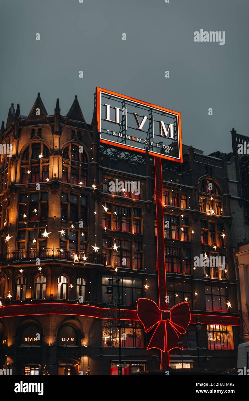 The building is decorated with a festive red bow and golden garlands ...