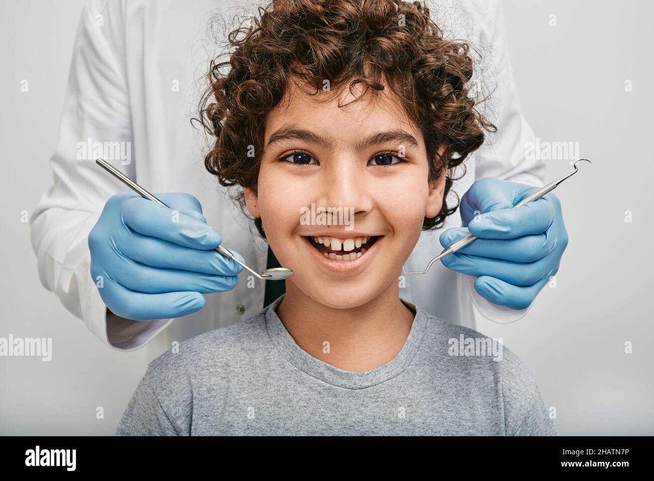 Positive boy with toothy smile during inspection of oral cavity by ...