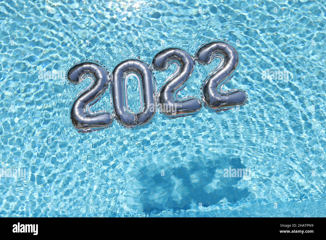 Helium balloons with numbers 2022 lying on water in swimming pool top ...