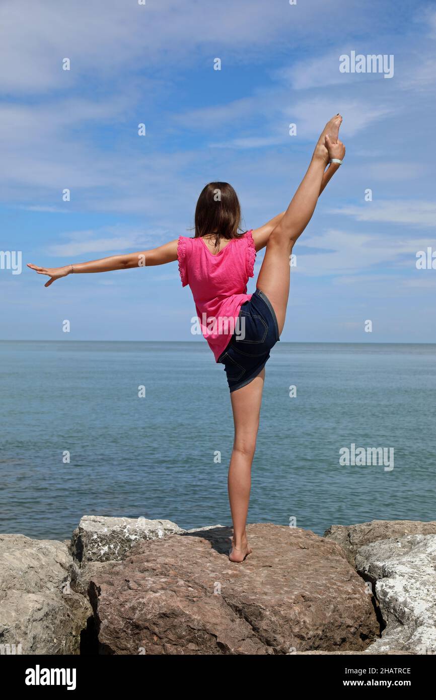 caucasian girl performing rhythmic gymnastics exercises with the leg up ...