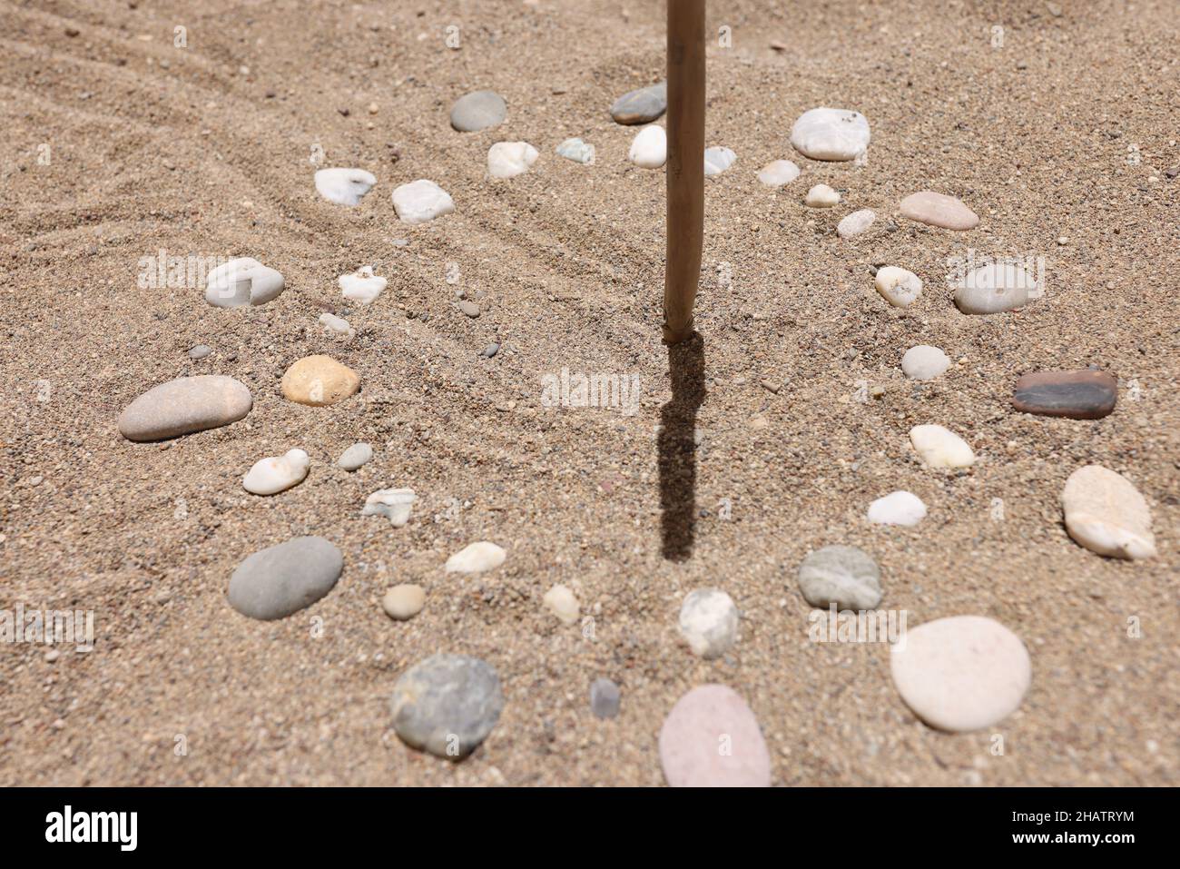 Sundial made of stones on sand closeup background Stock Photo - Alamy