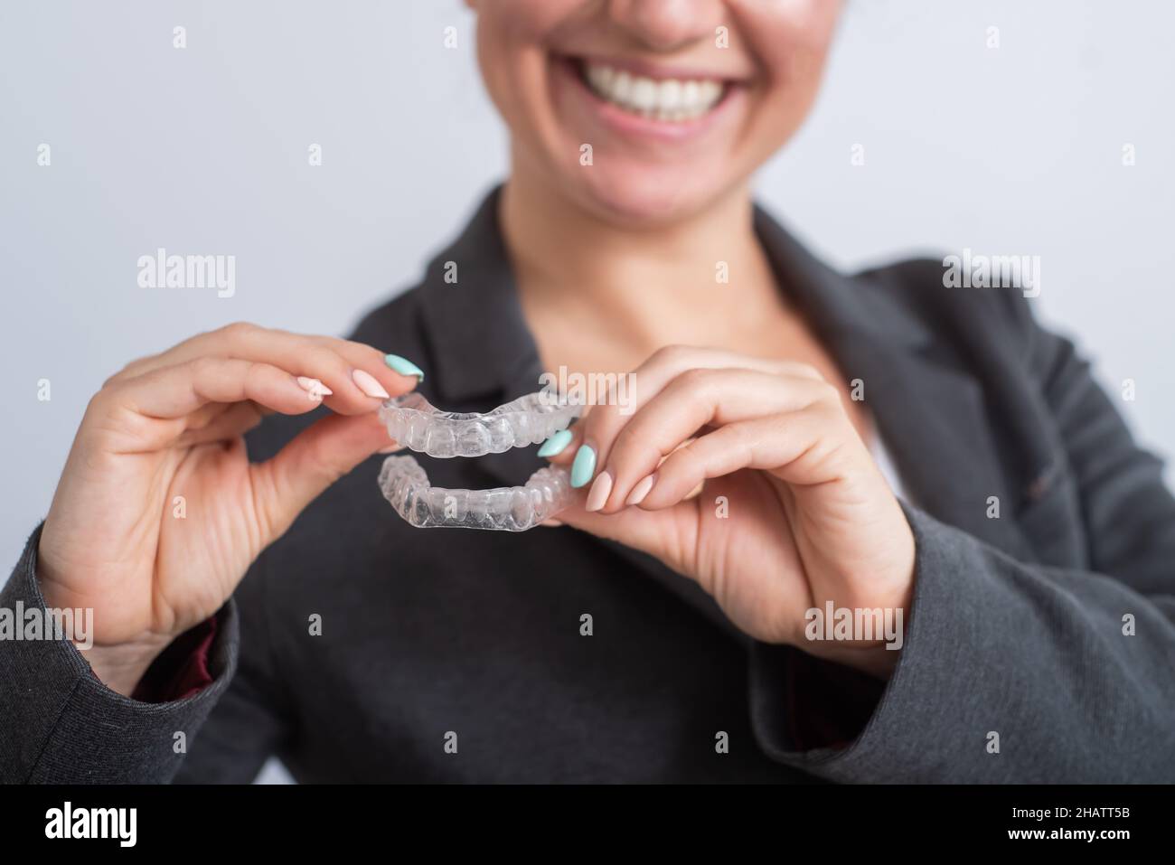 A woman is holding a transparent plastic mouth guard. Orthodontist's ...