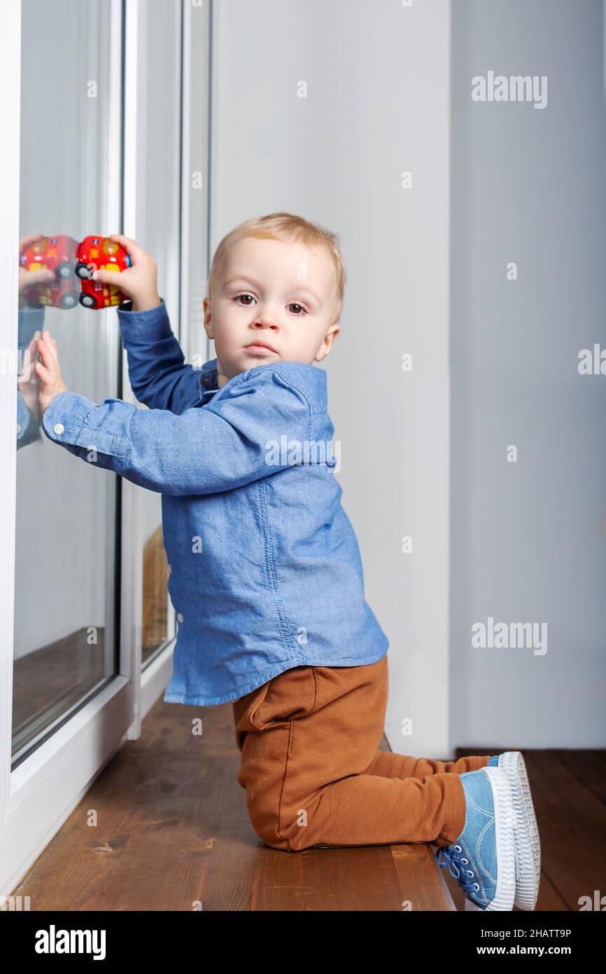Child playing dangerously on a window sill Stock Photo - Alamy