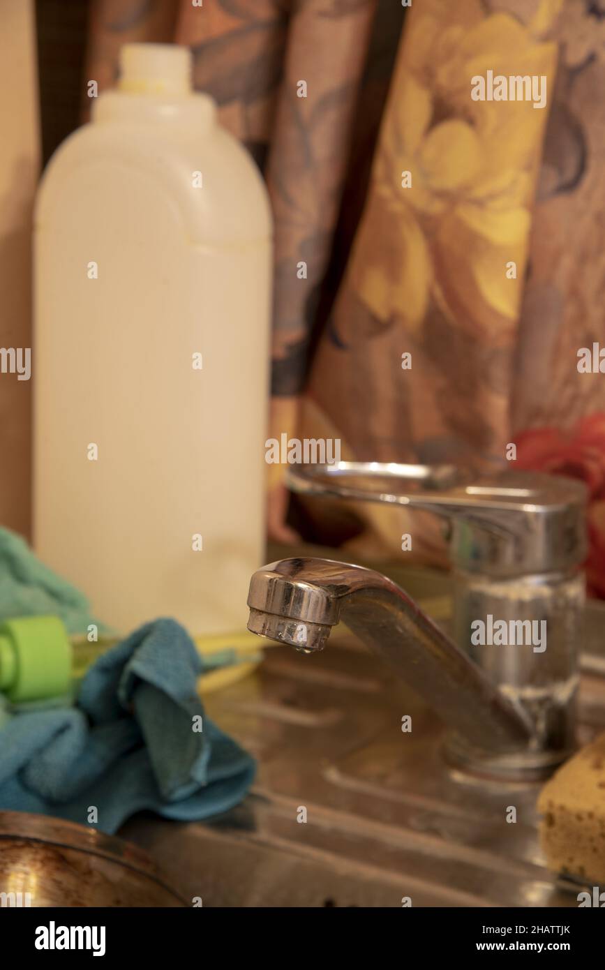 The water tap over the kitchen sink with dirty dishes. Focus on the ...