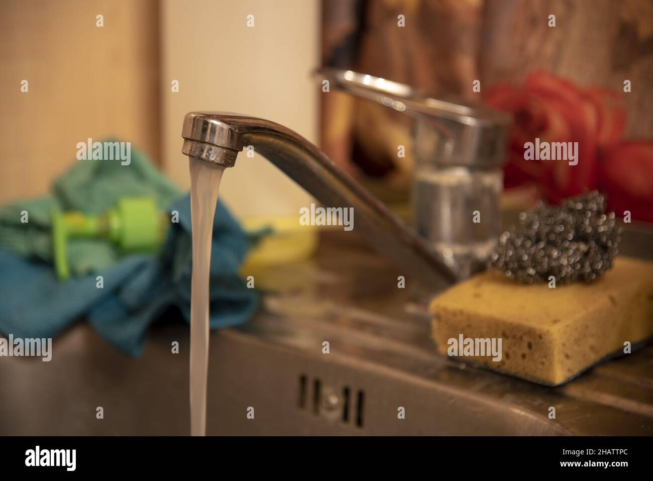 The water tap over the kitchen sink with dirty dishes. Focus on the ...