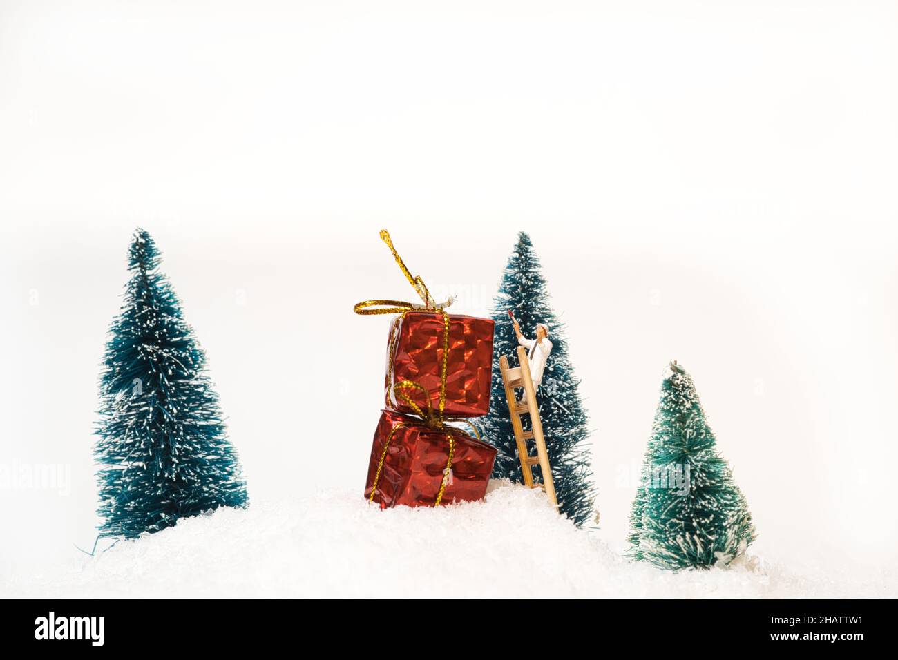 Miniature figure painter painting red gift packages in a snowy area ...