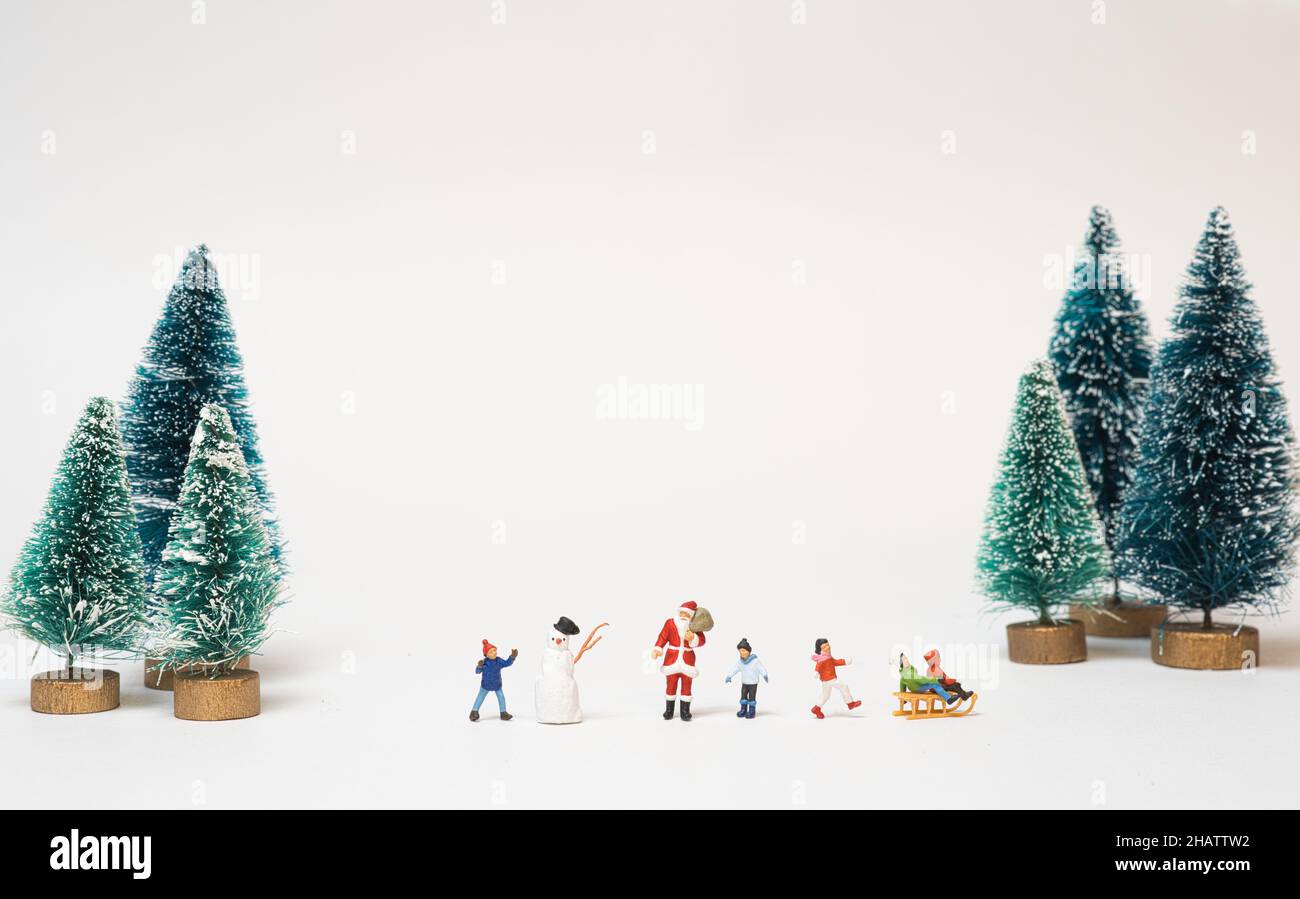 Christmas scene of miniature figures of Santa Claus and kids playing in ...