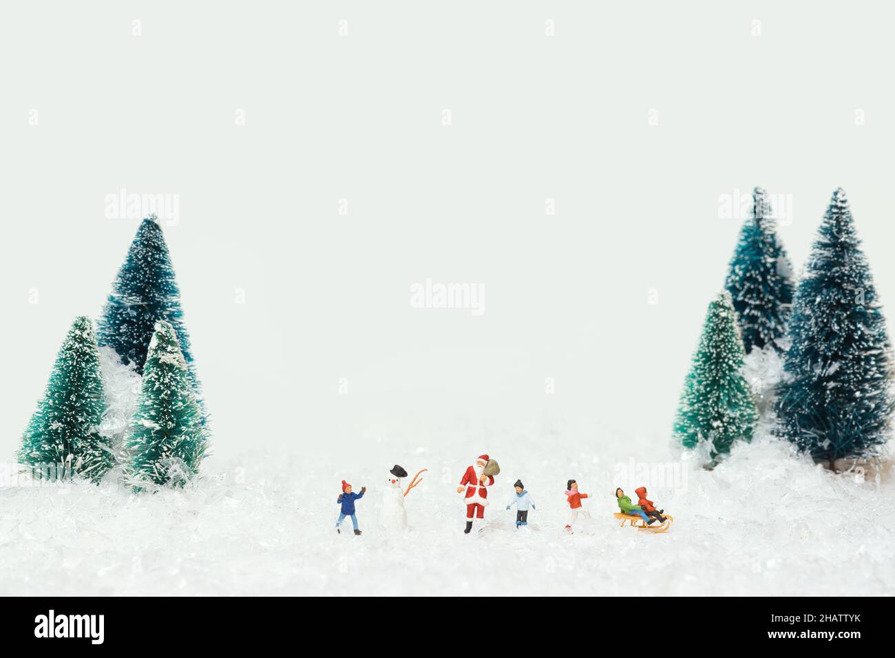 Christmas scene of miniature figures of Santa Claus and kids playing in ...