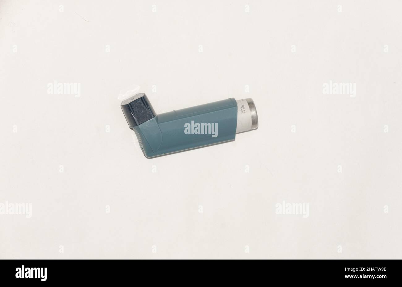 Top view of a blue inhaler on the white surface with space for text ...