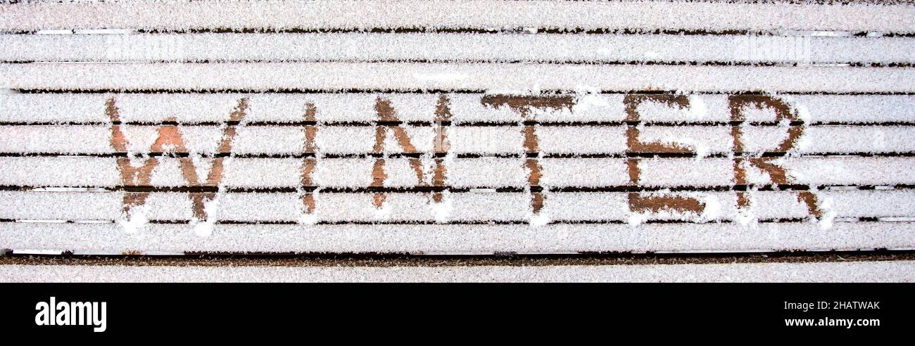 The word WINTER written in the snow on a bench in a winter park Stock ...