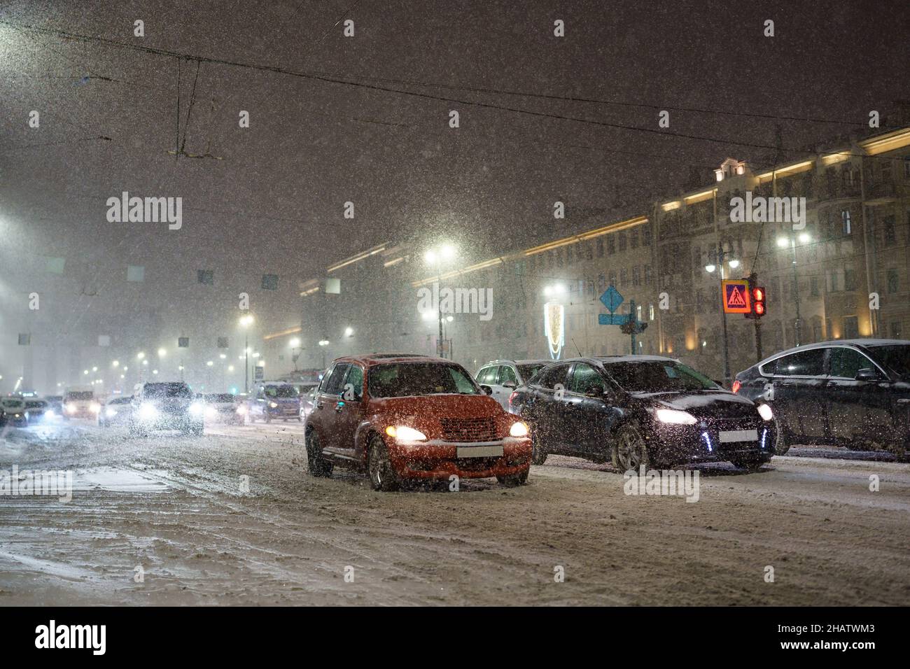 Traffic jam on winter road during snow blizzard at night, transport ...