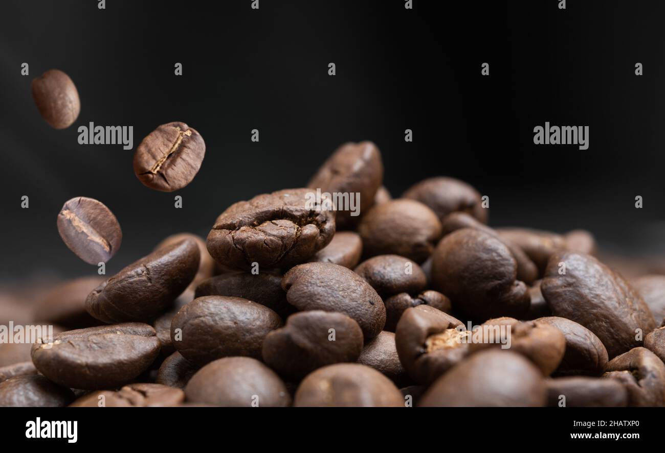 Aroma roasted coffee beans with smoke rising over dark background Stock ...