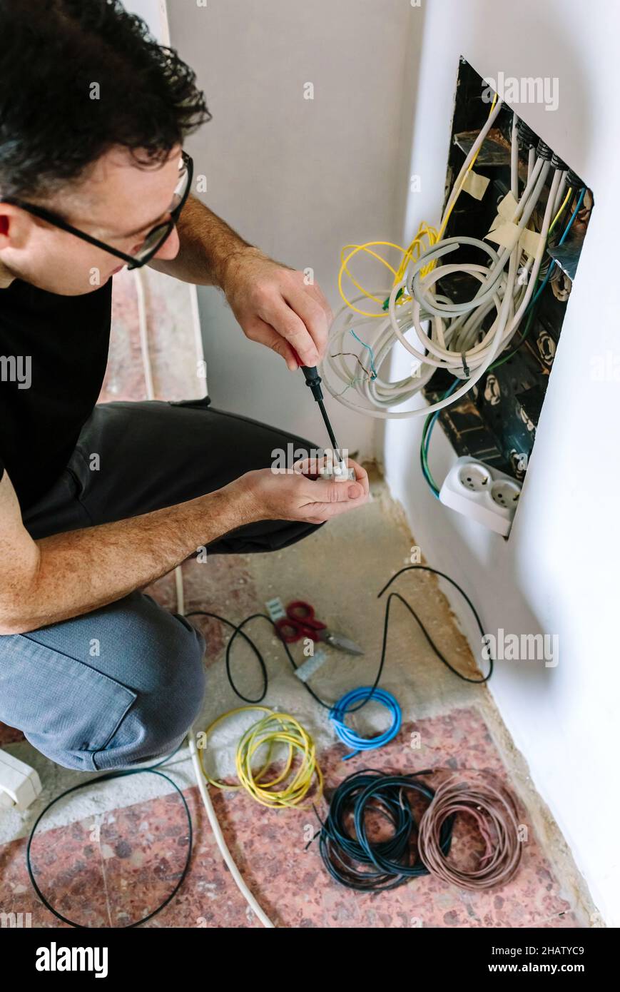 Technician with screwdriver and terminal strip installing ...