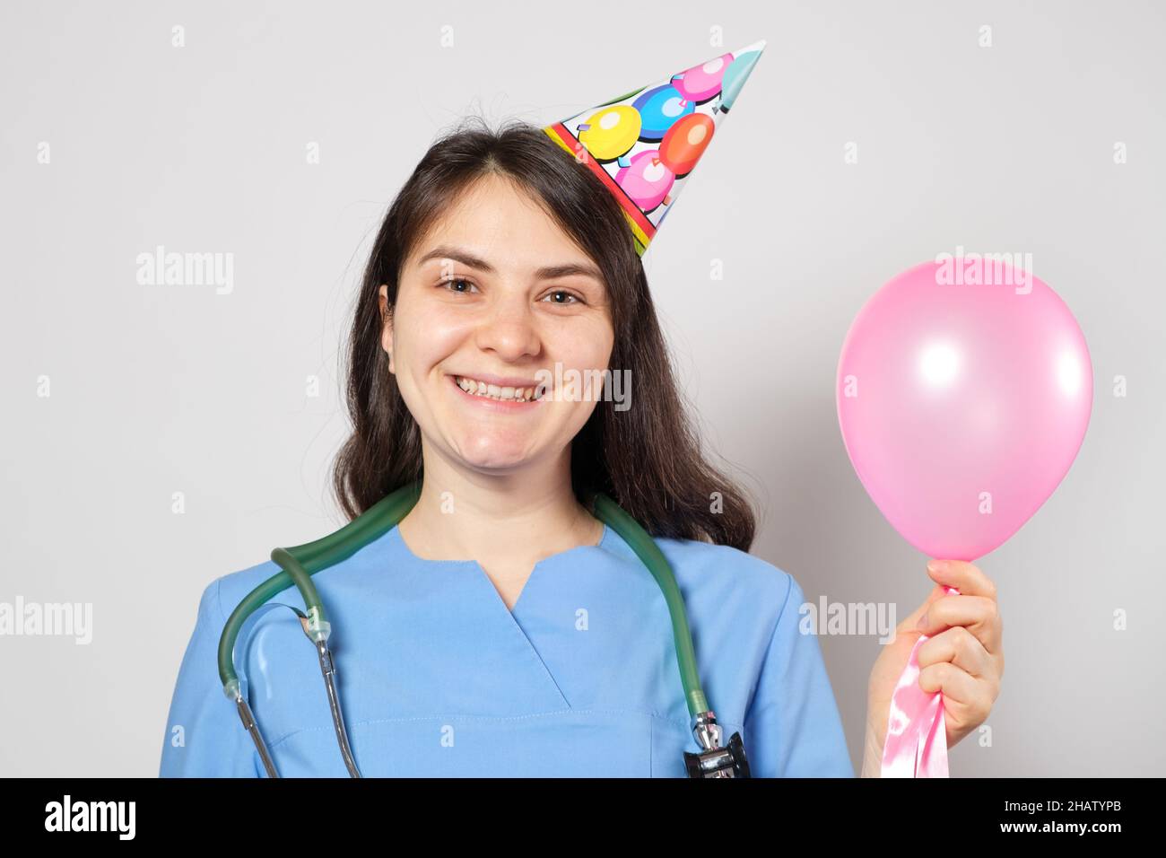 The doctor holds a festive balloon and smiles, happy doctor's day Stock ...