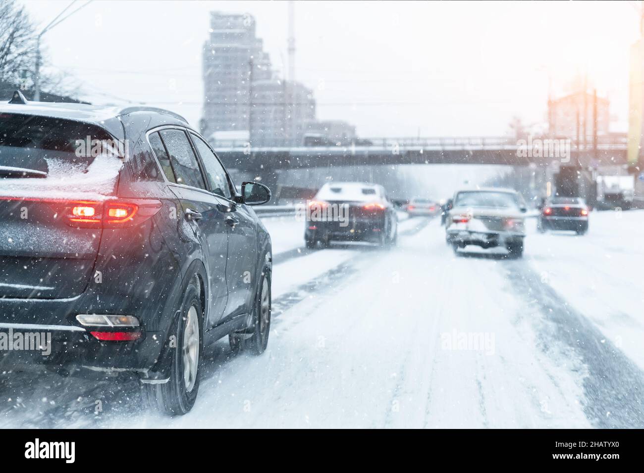 Scenic view snow covered city highway slippery road drive cars moving ...