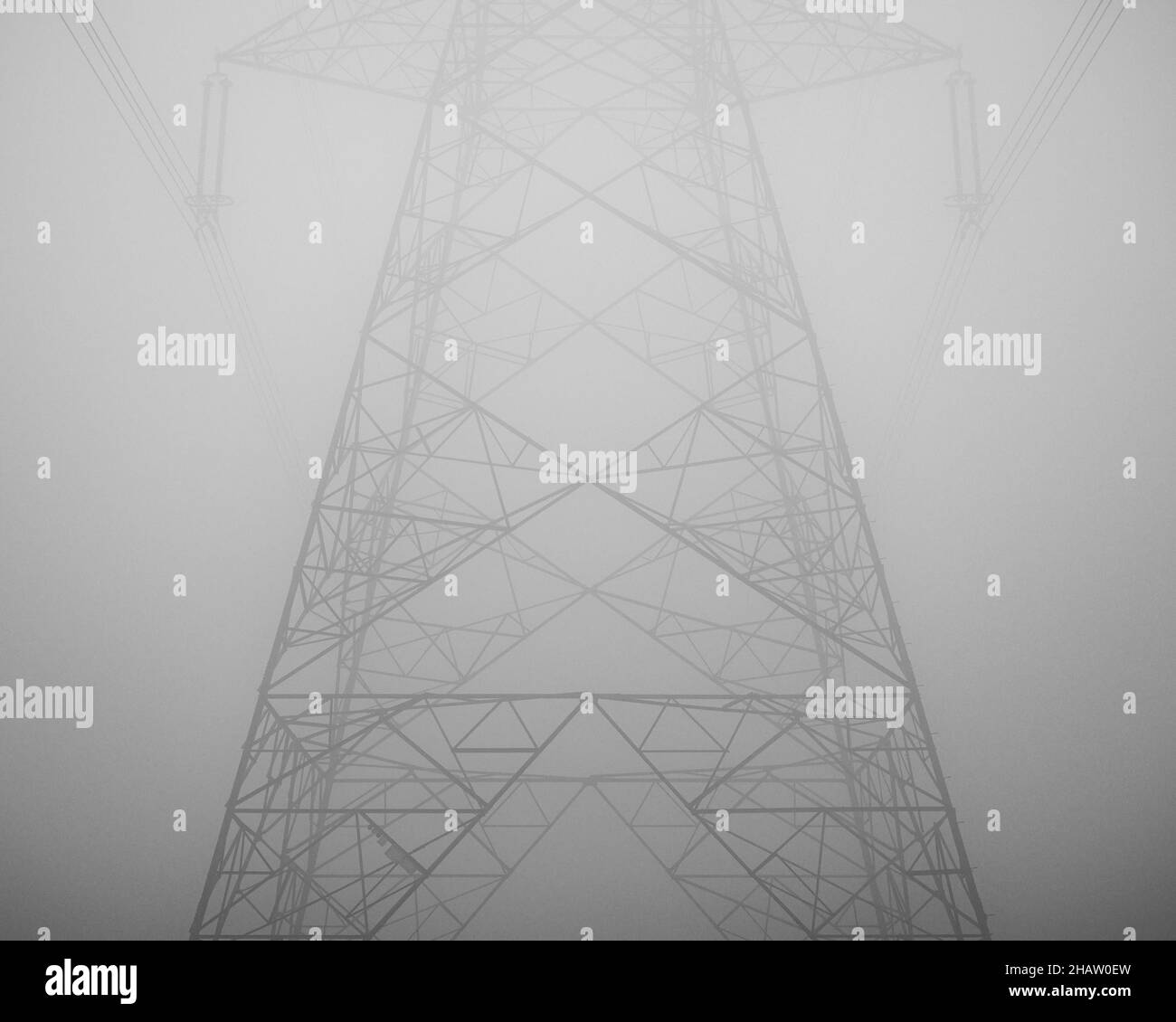 High voltage transmission tower under fog Stock Photo - Alamy