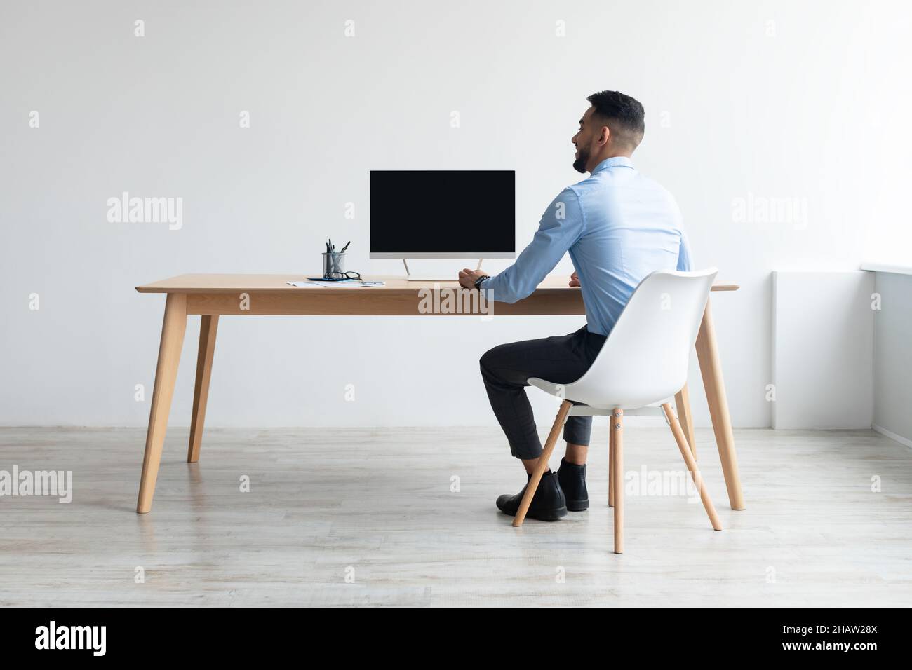 Arab man looking at blank empty computer monitor Stock Photo - Alamy