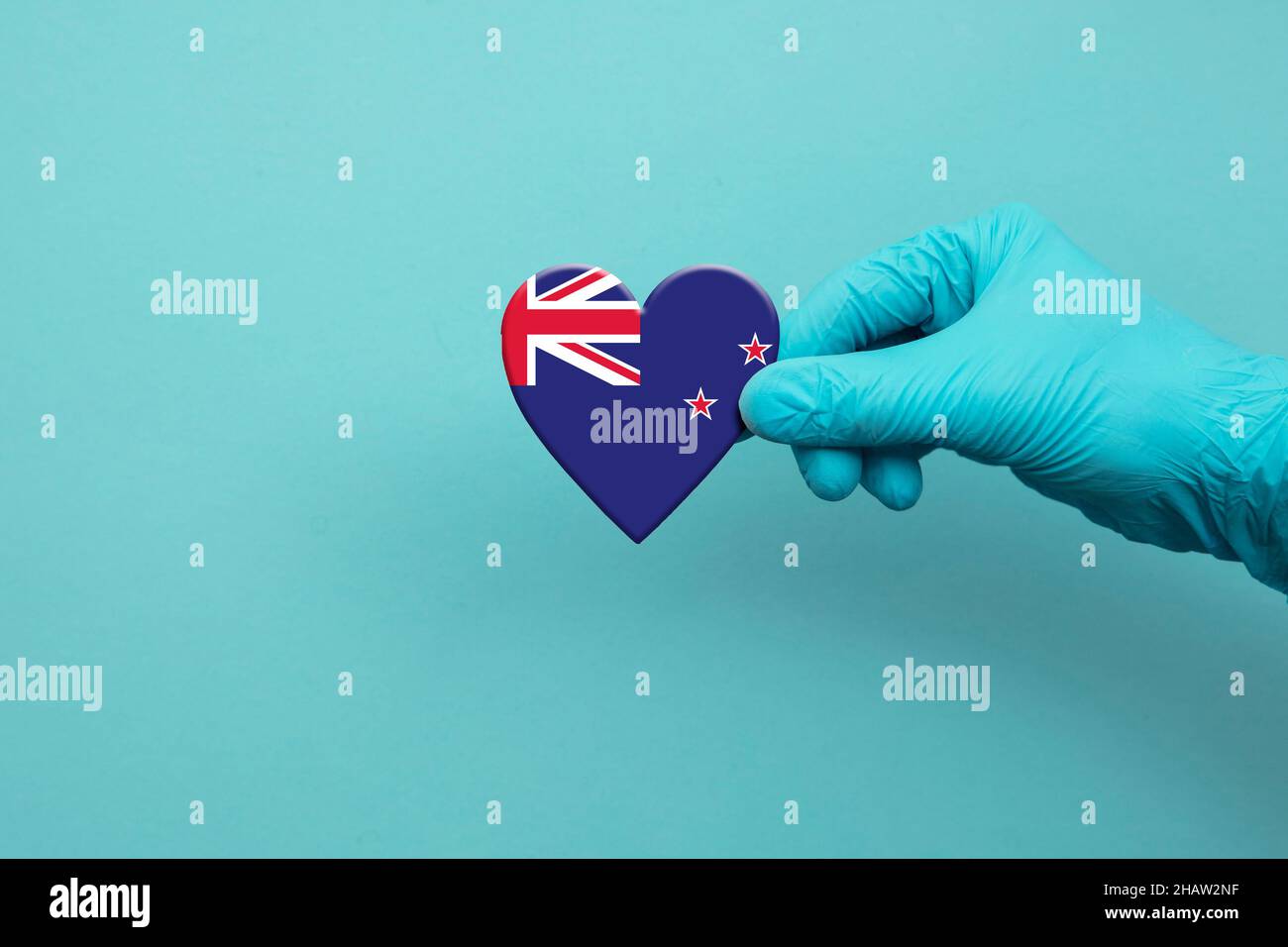 Medical workers hand wearing surgical glove holding New Zealand flag ...