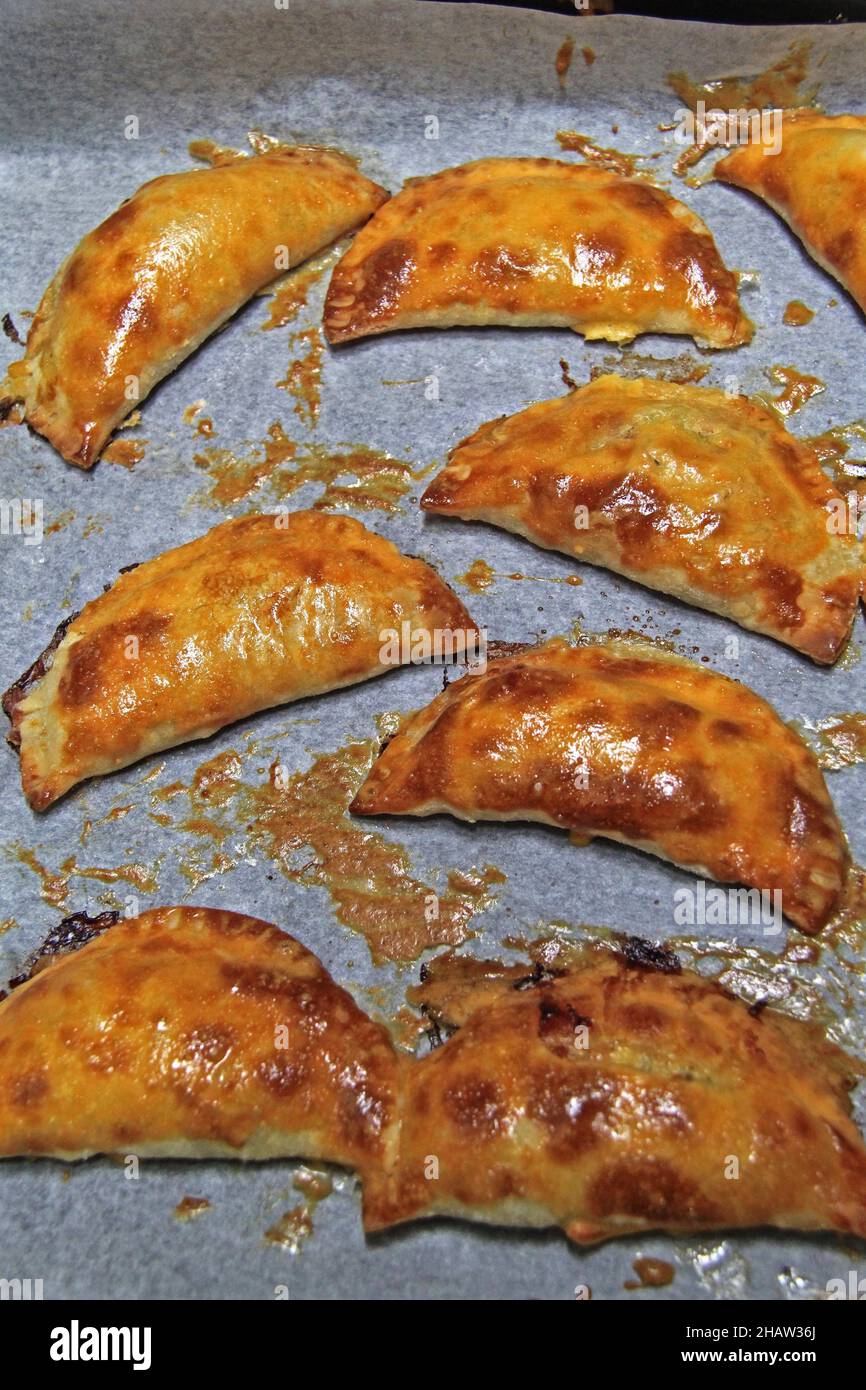Baking tray with baked empanadas, empanadas on baking paper, tapa ...