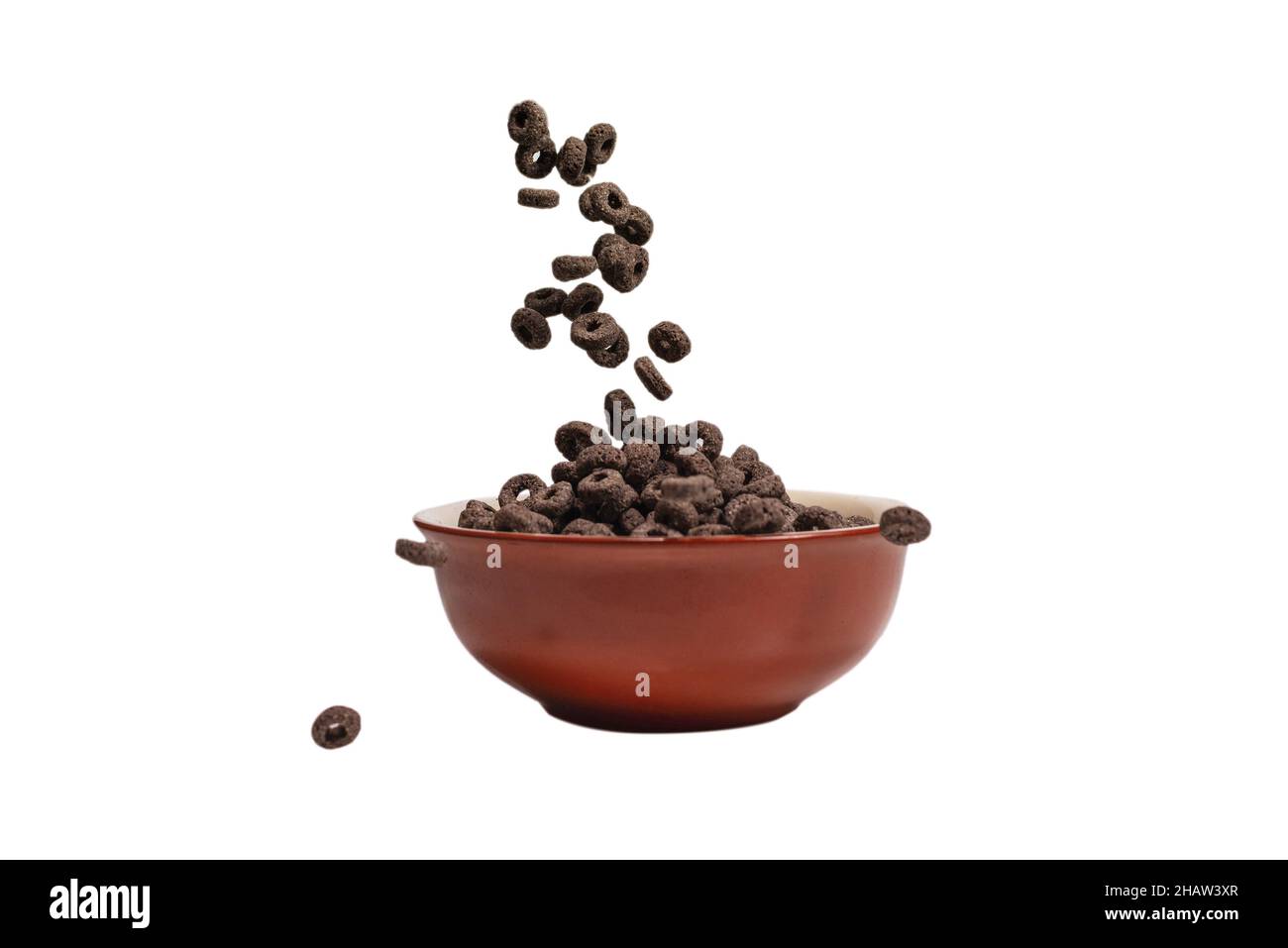 Chocolate rings cereal spill out into a bowl. Breakfast. Isolated on a ...