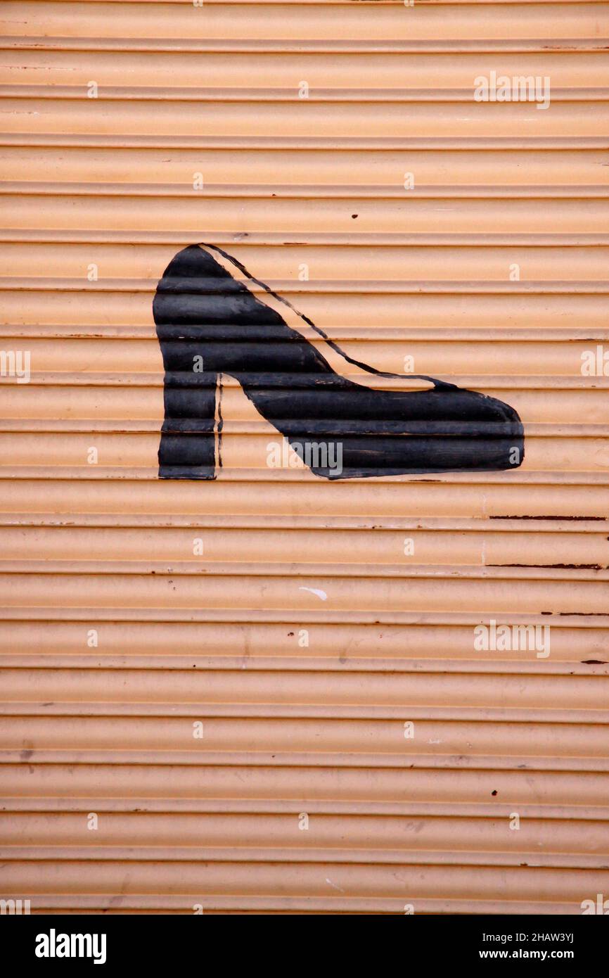 Rose coloured metal shutter door from shoe shop with painted black ...