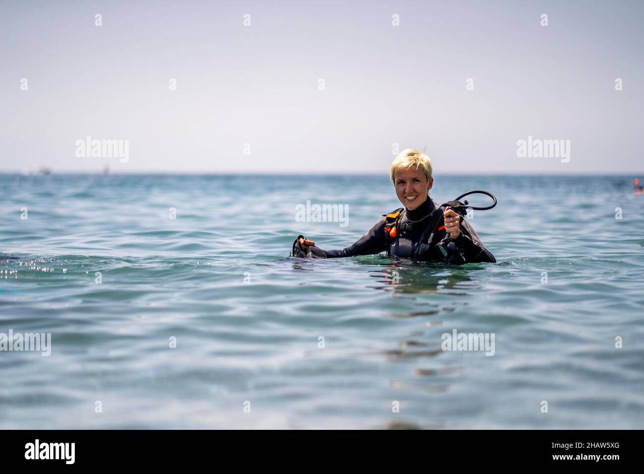 Happy woman getting ready to scuba diving in Mediterranean Sea ...