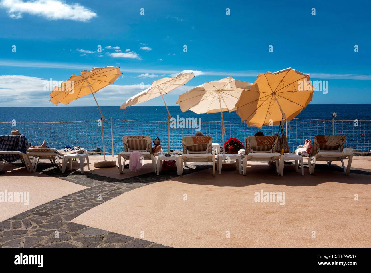 Sun loungers and parasols by the swimming pool overlooking the Atlantic ...