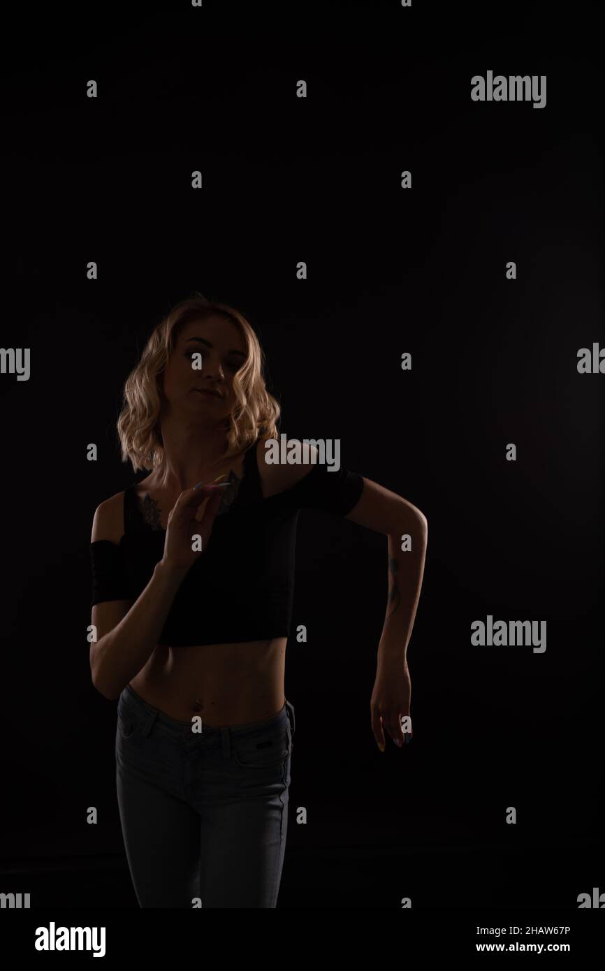slender woman dancing to music in the dark Stock Photo - Alamy