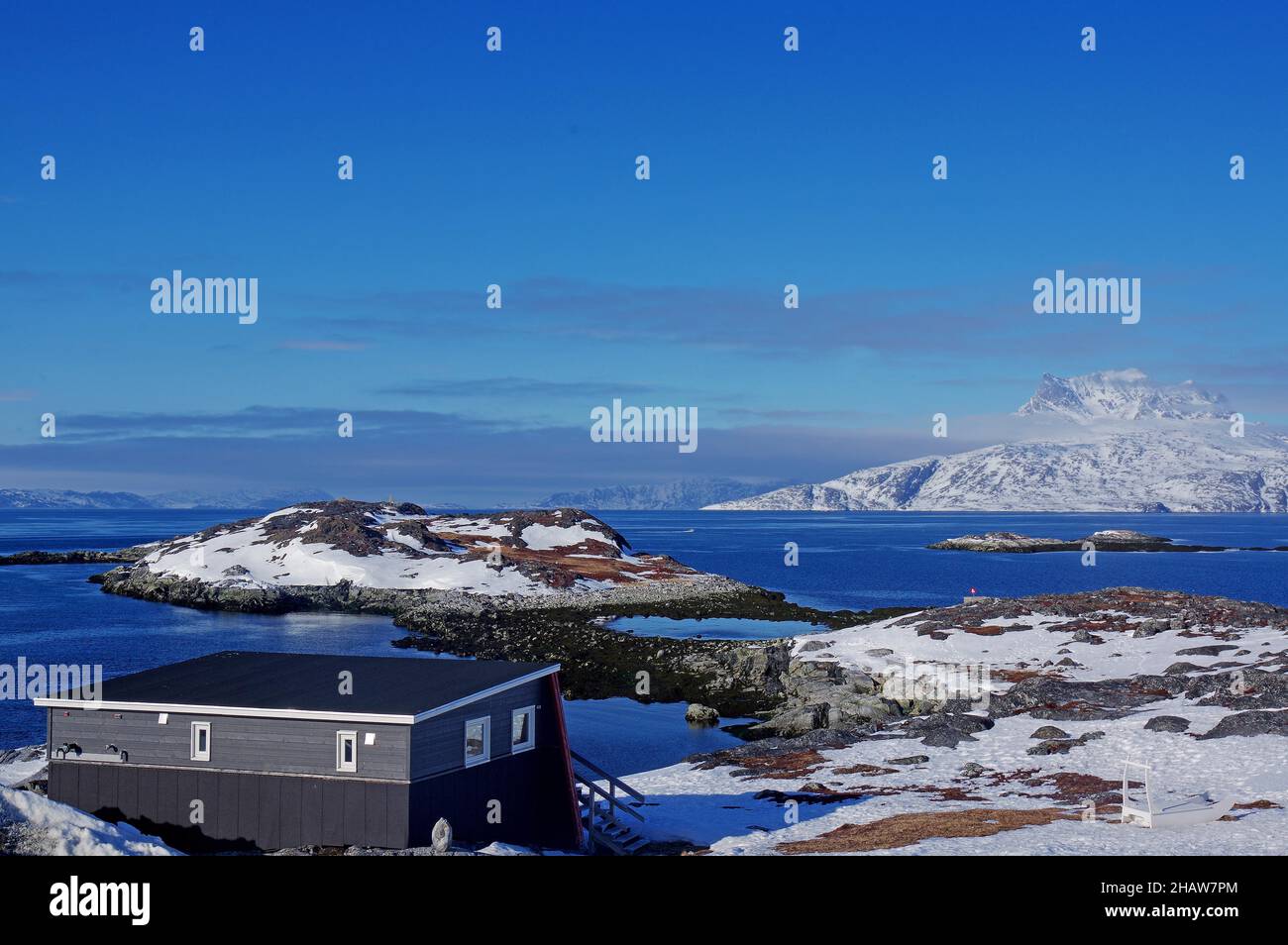 Single house, rugged, snowy mountain landscape, small rocky islands ...