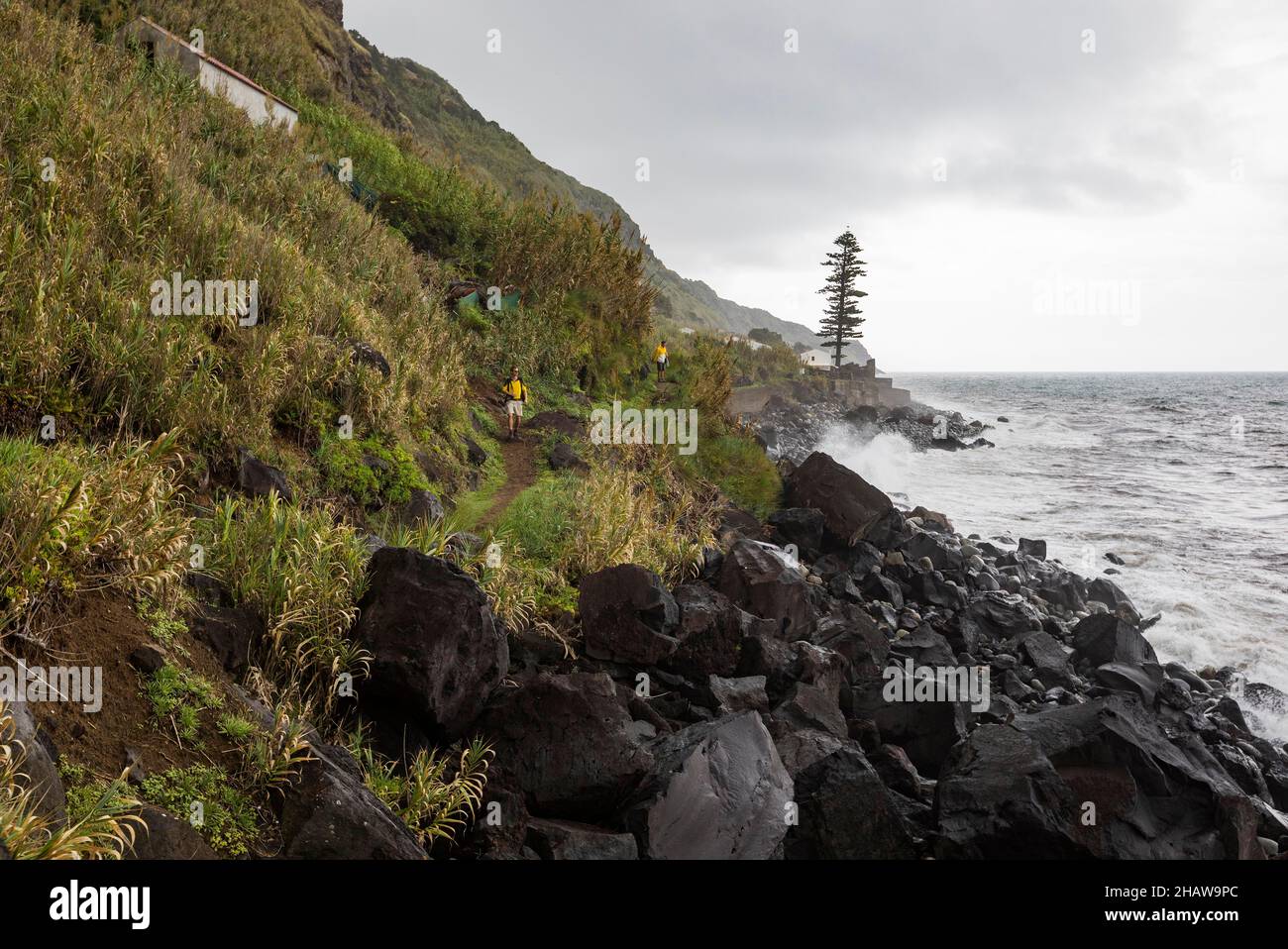 Hikers on the path along the coast to Rocha da Relva, Sao Miguel Island ...