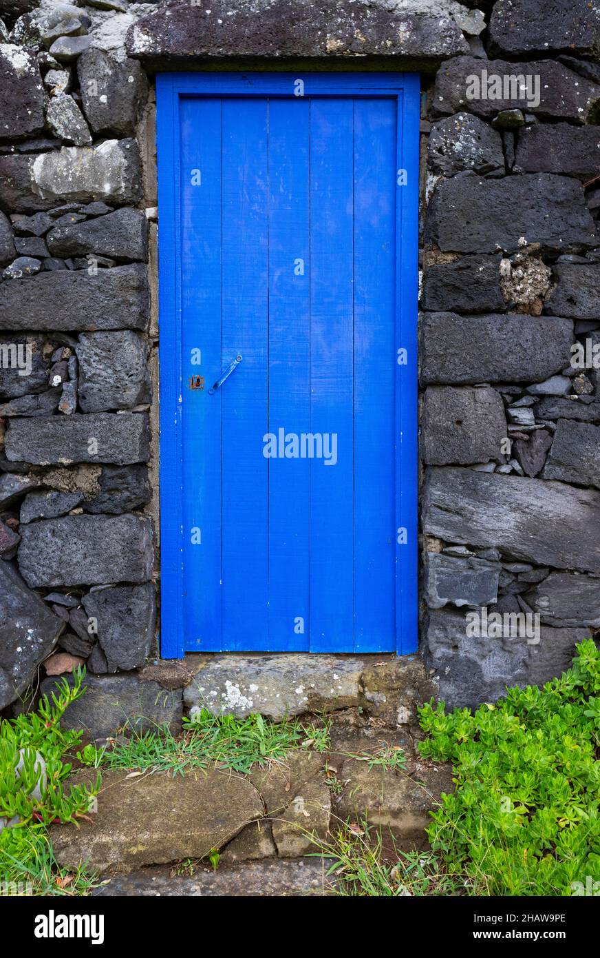 Lava stone house facade with blue front door, Rocha da Relva, Sao ...