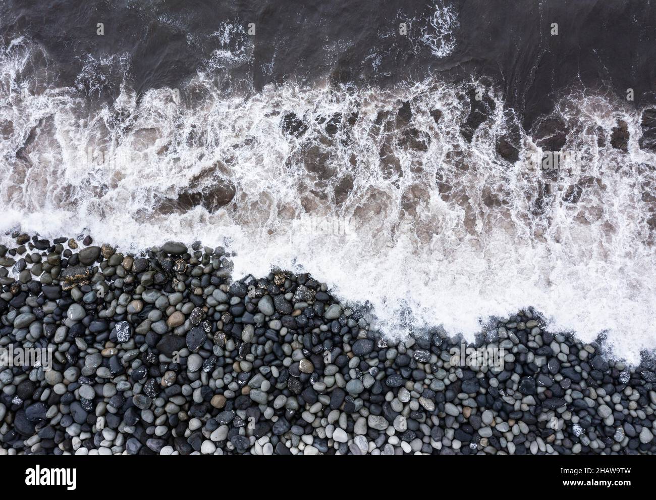 Drone shot, surf with big round stones on the beach of Rocha da Relva ...