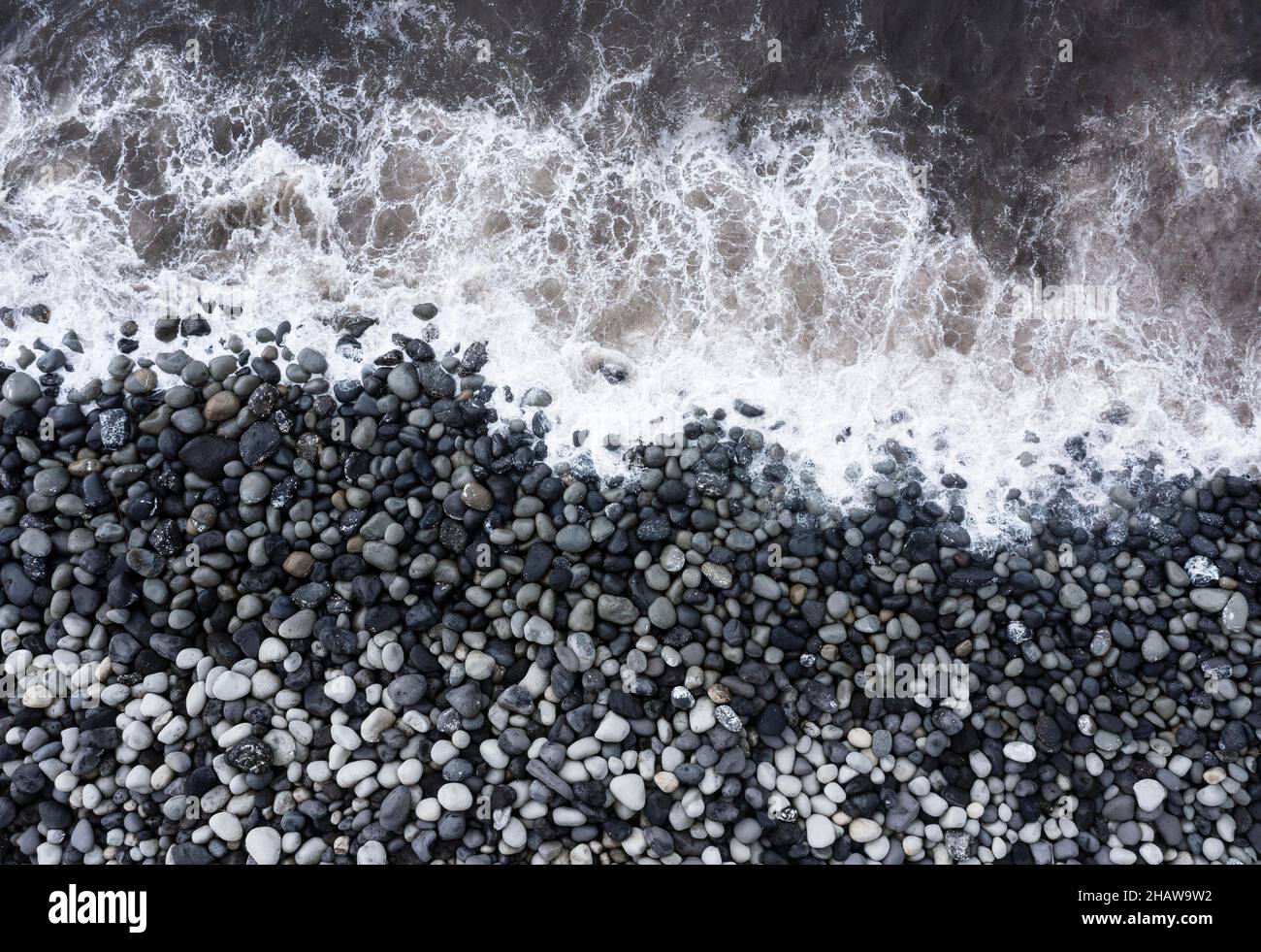 Drone shot, surf with big round stones on the beach of Rocha da Relva ...