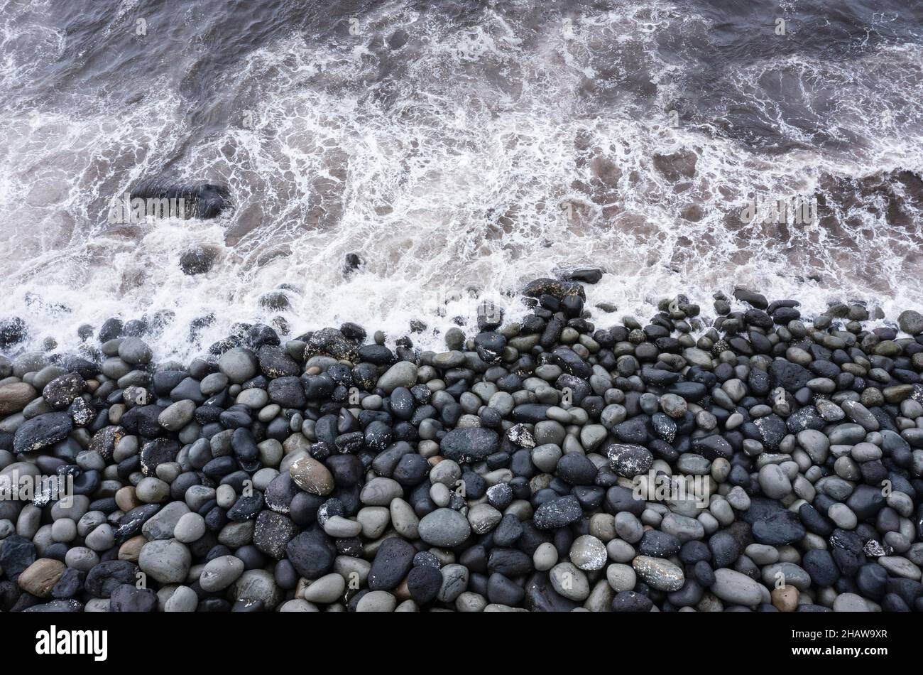 Drone shot, surf with big round stones on the beach of Rocha da Relva ...