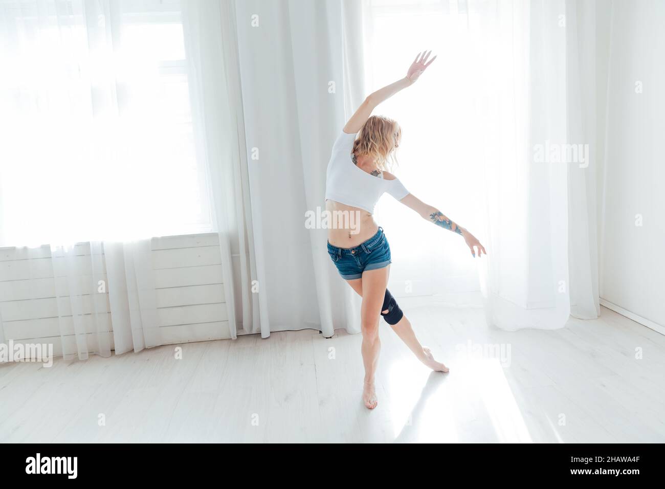 beautiful slender woman dancing to music in a white hall Stock Photo ...