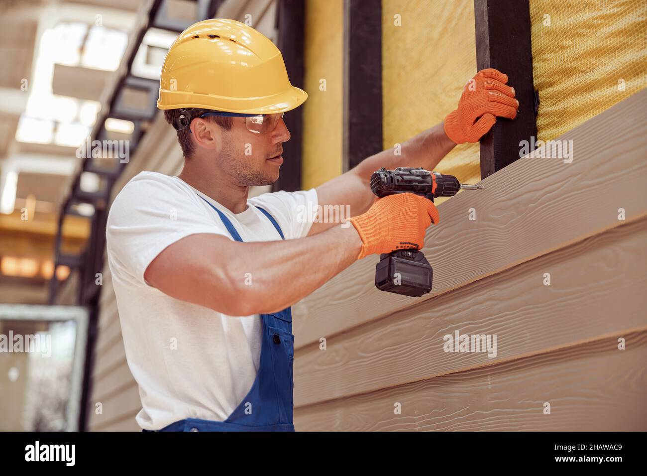 Male builder using power drill at construction site Stock Photo - Alamy