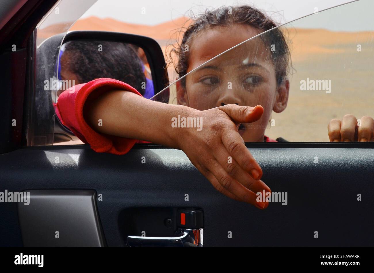 Begging girl reaches out Hand in the car Stock Photo - Alamy