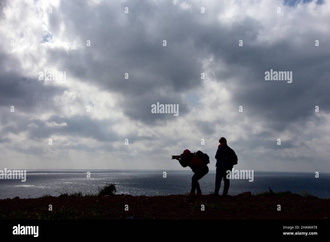 Women photographers with camera at the cloudy sea, mood with clouds at ...