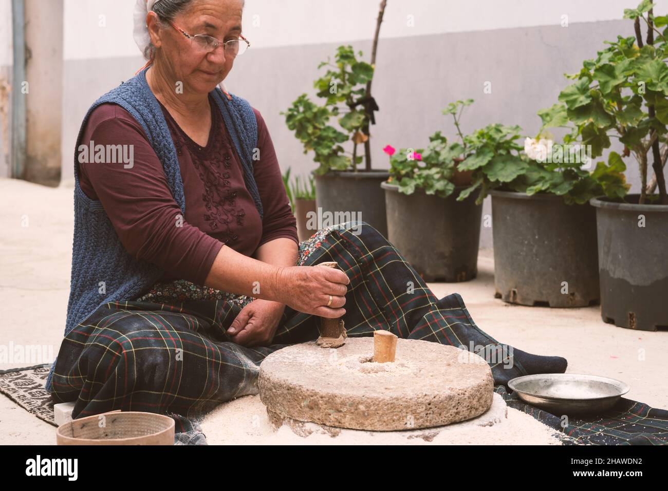 The ancient hand mill or quern stone, grinds the grain into flour. Old ...