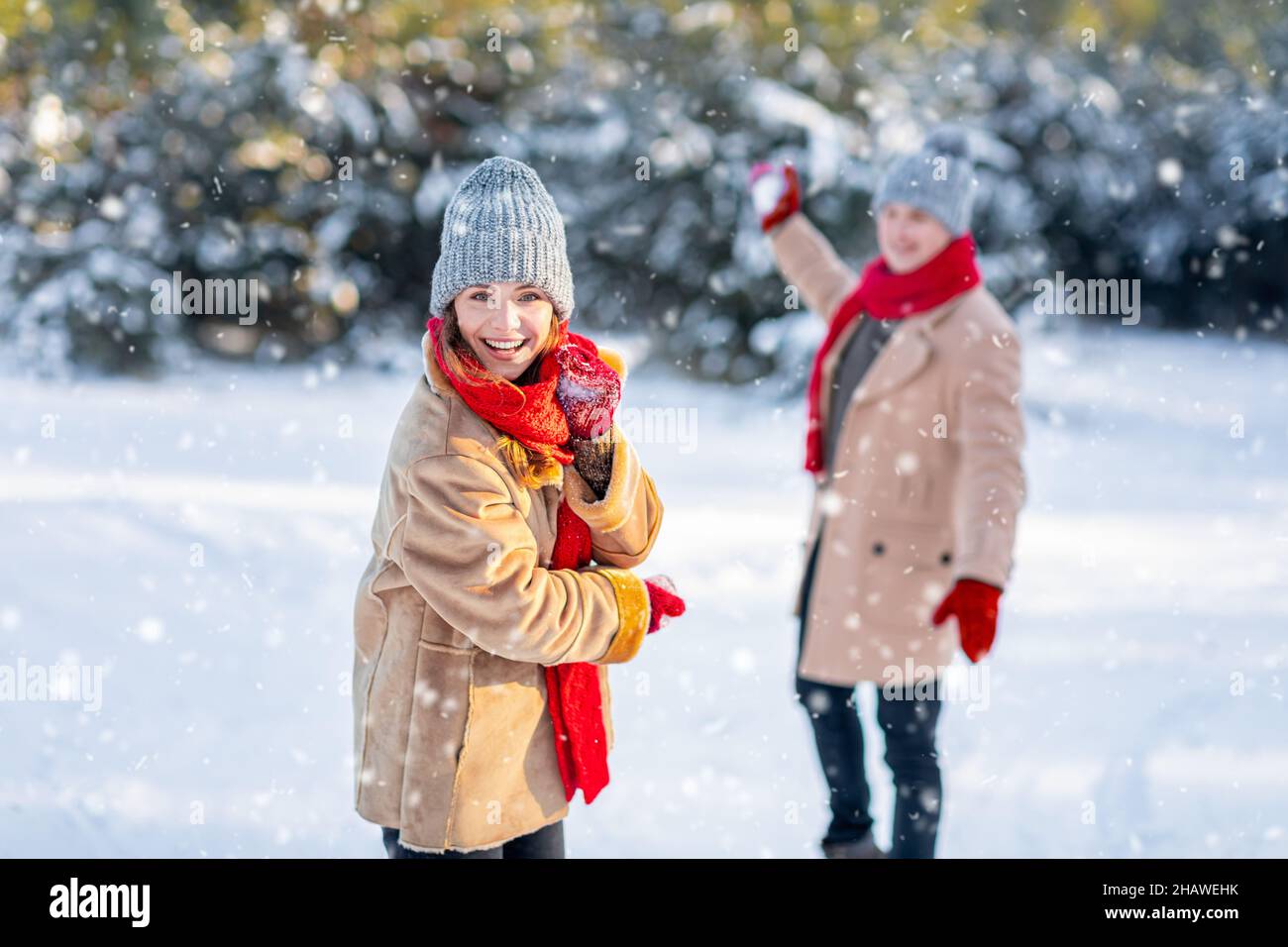 Joyful romantic couple having snow fight at winter forest, panorama ...