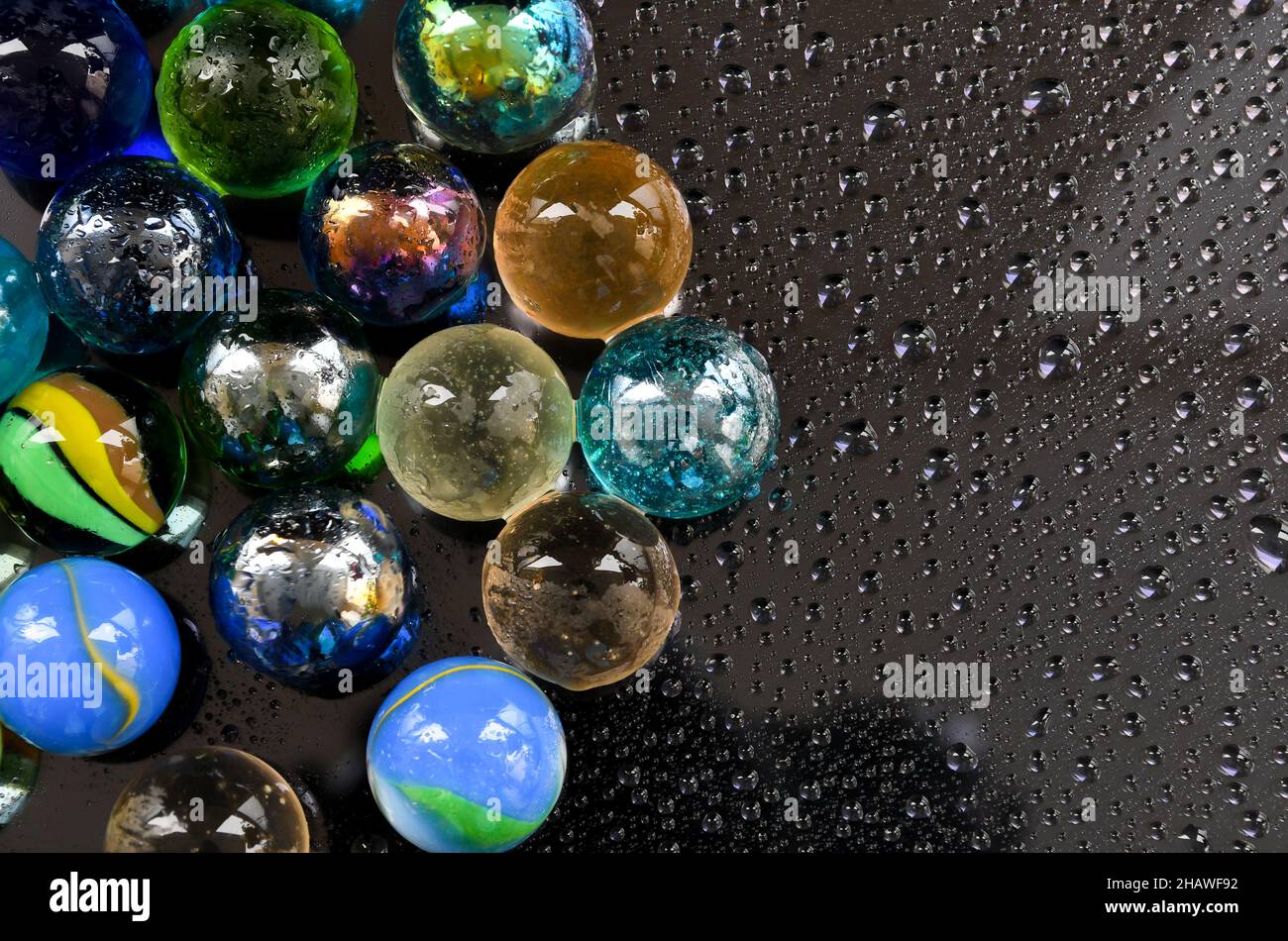 Group of colorful small balls on a wet surface Stock Photo - Alamy