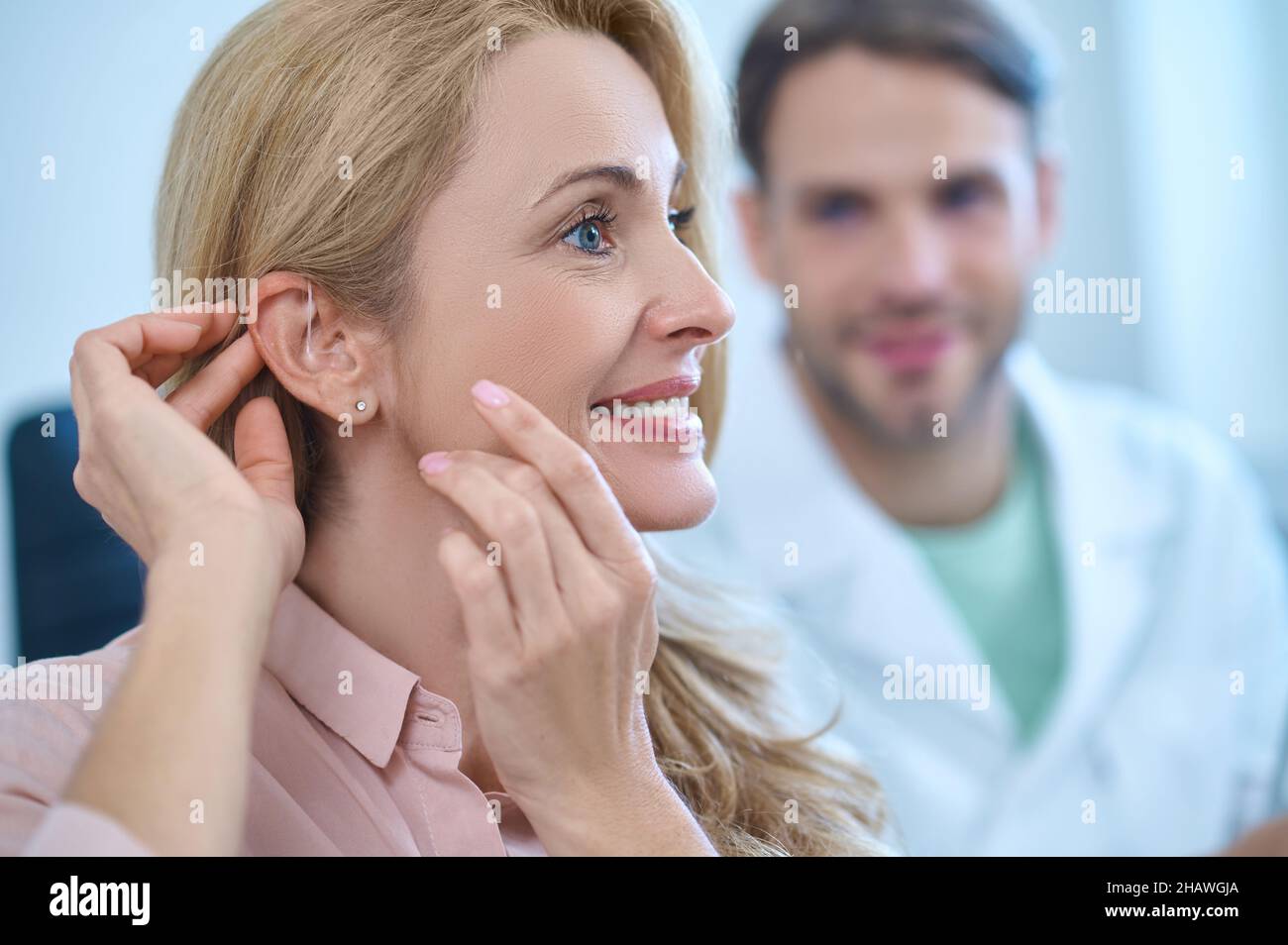 Profile of woman with her hands touching ear Stock Photo - Alamy