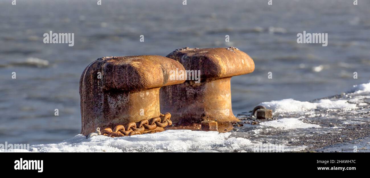 Closeup of two old rusty bollards in the sea Stock Photo - Alamy