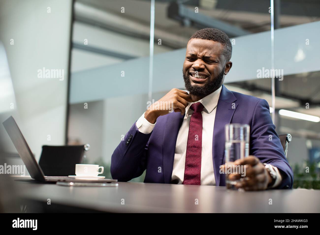 Irritated black manager untying his suit, office interior Stock Photo ...