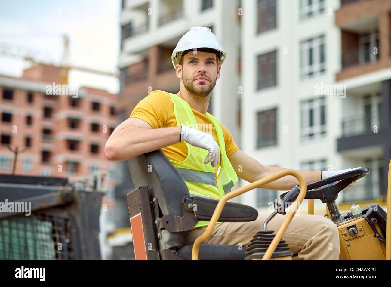 Pensive man driving excavator at construction site Stock Photo - Alamy